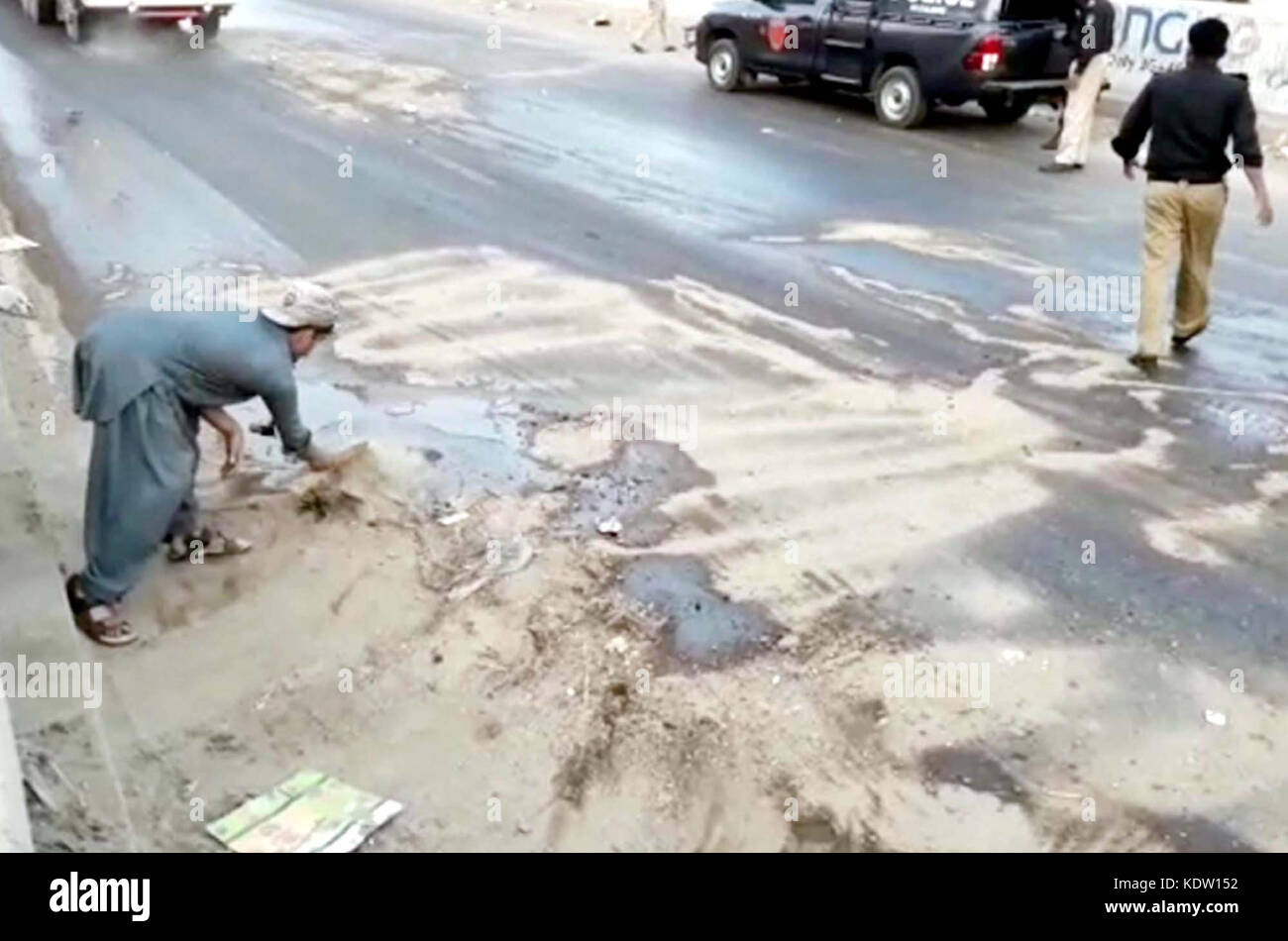 Traffic police official lays sand on slippery road after traffic ...