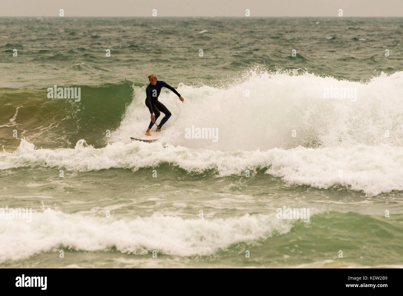 Surfer riding a wave in big waves and strong winds from storm, ex ...