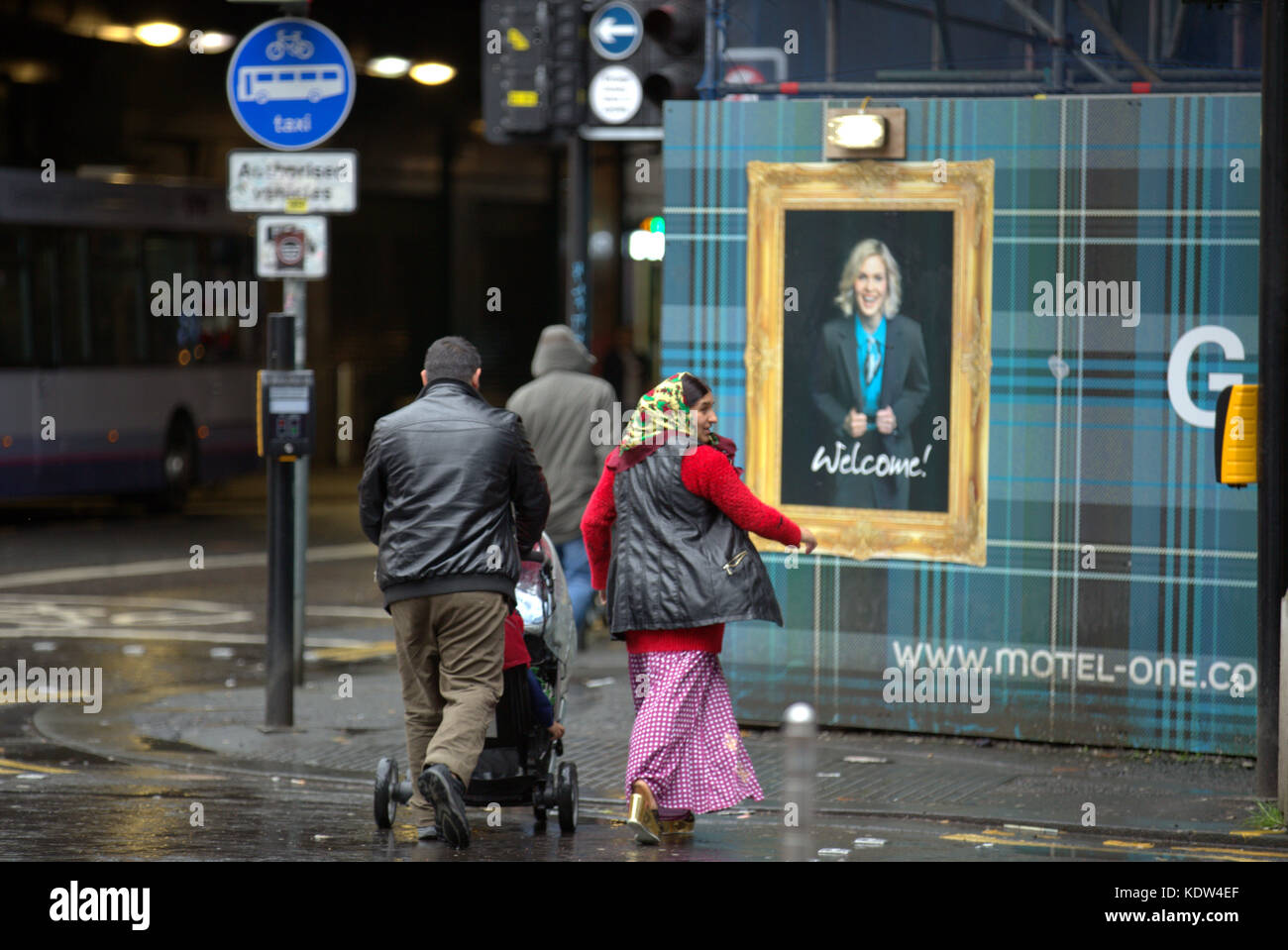 family couple pushing pram in front of welcome advert Muslim woman in ...