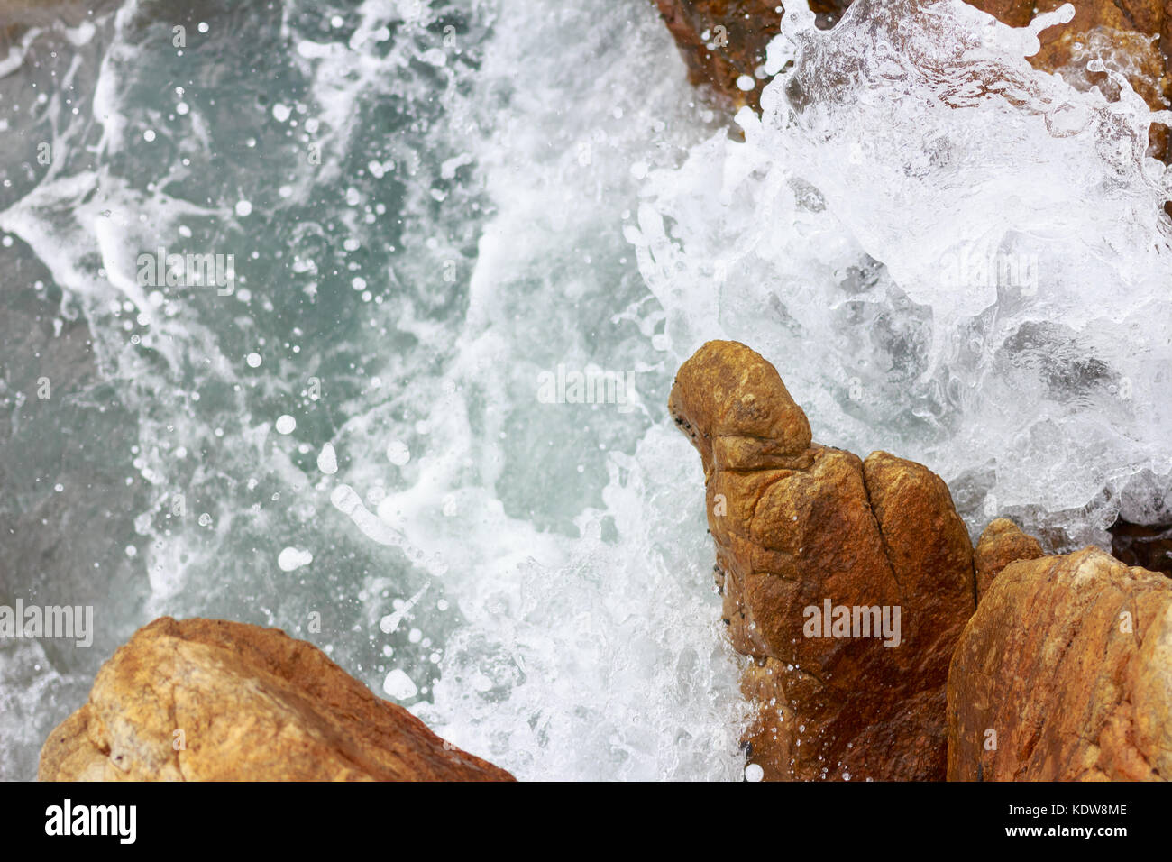 Water splashing. Crystal clear sea water beating against the rocks and ...