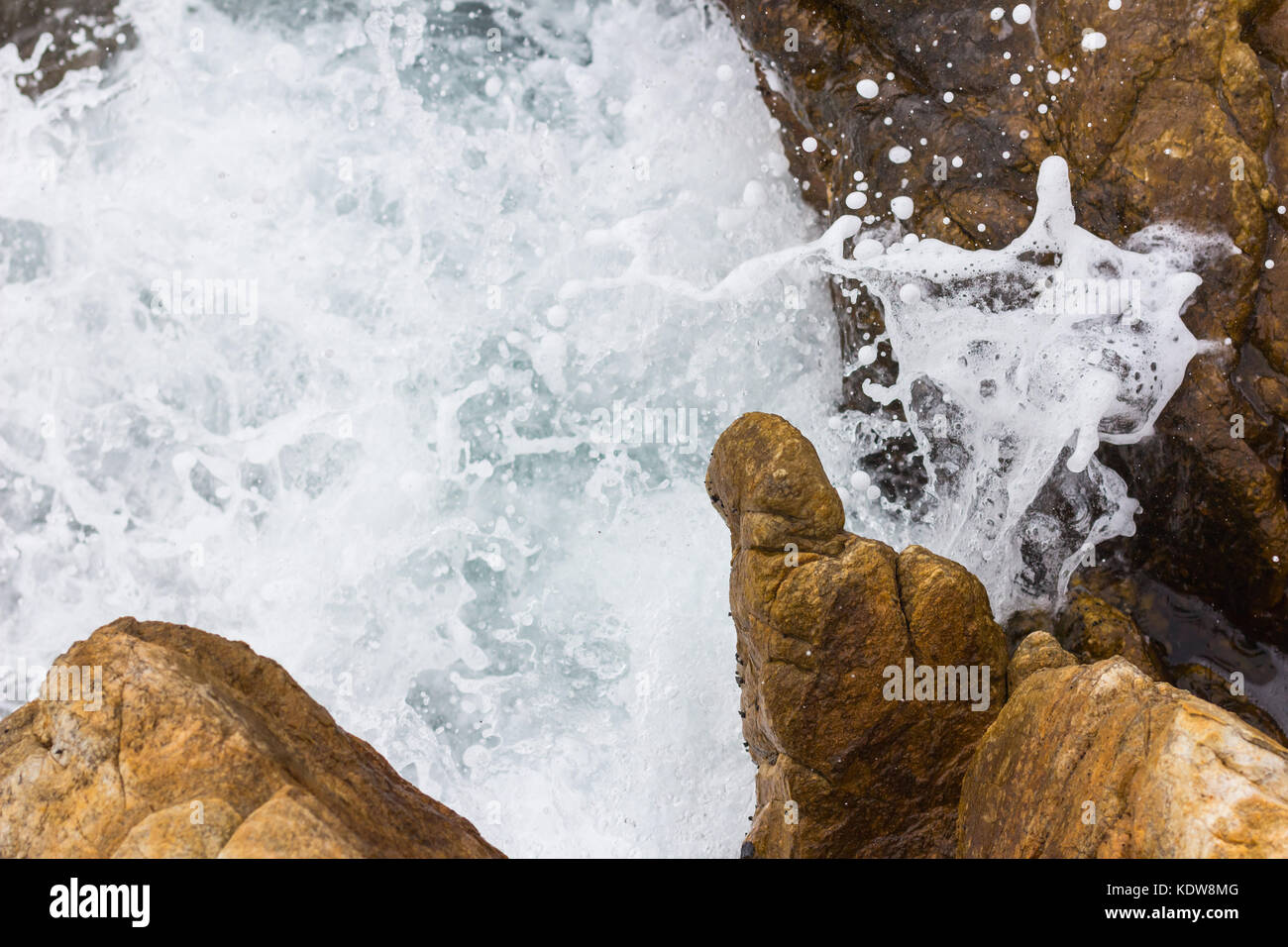 Water splashing. Crystal clear sea water beating against the rocks and ...