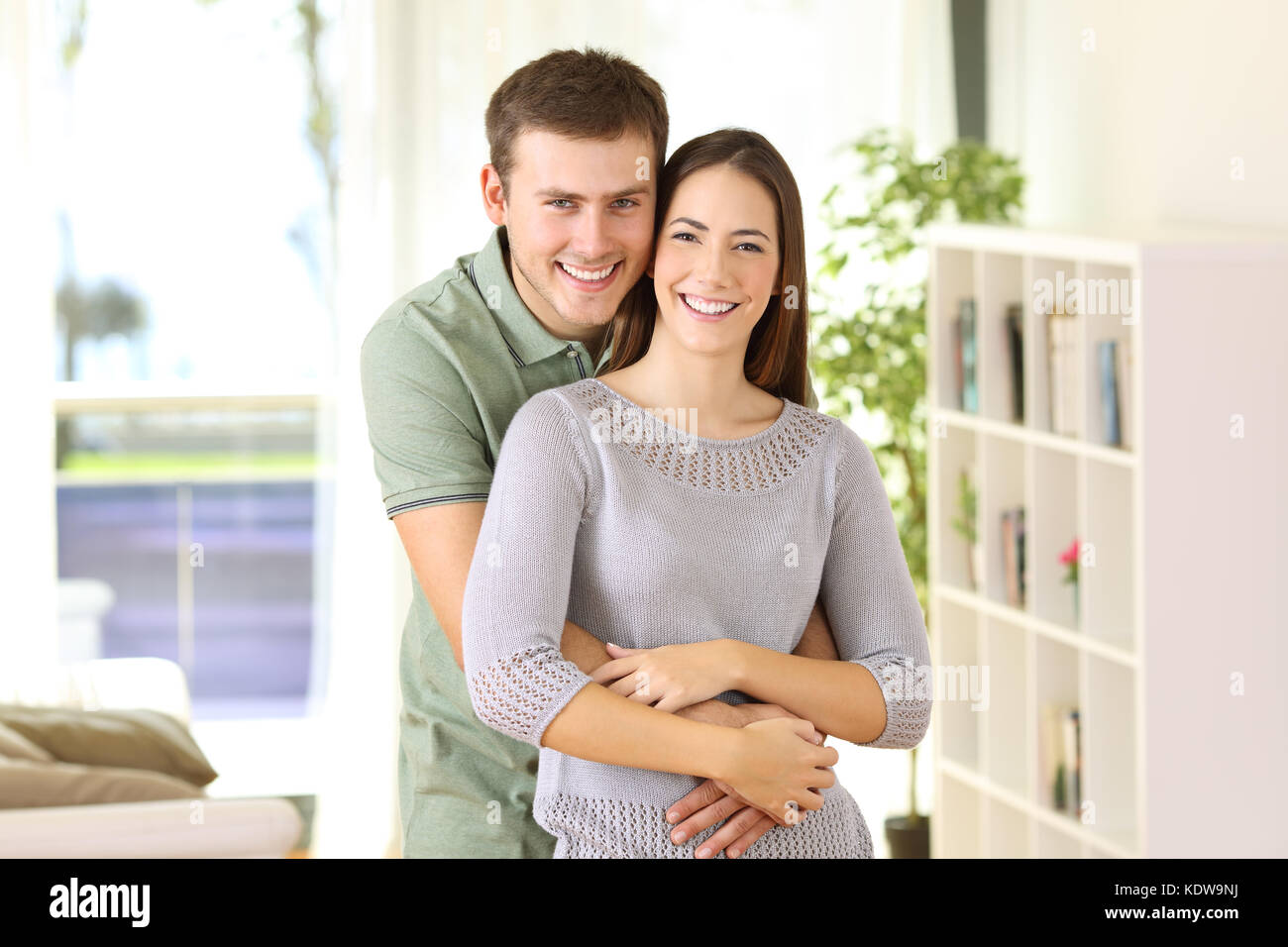 Portrait of a proud homeowners posing looking at you standing in the ...
