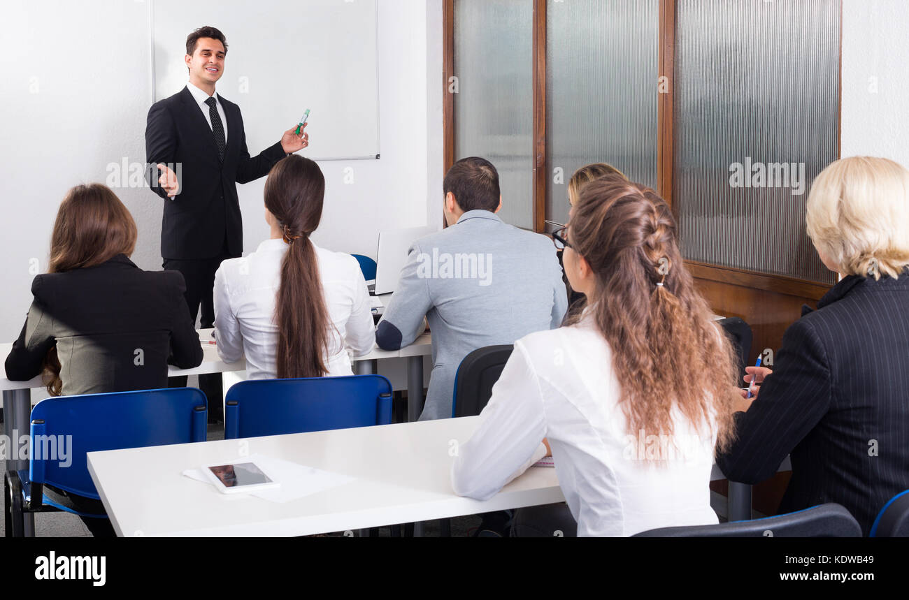 Attentive business students with teacher in classroom Stock Photo - Alamy