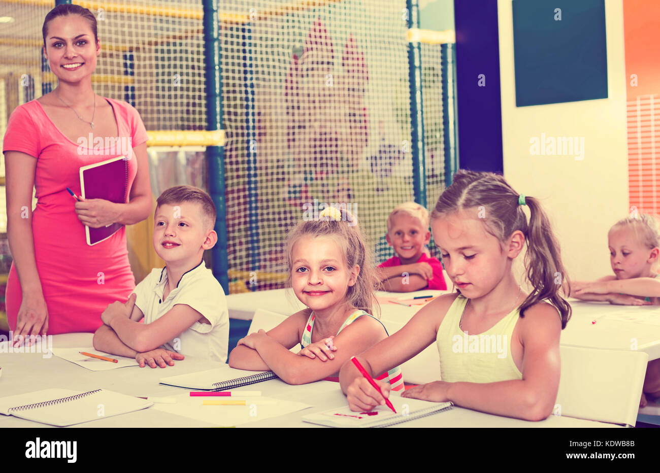 happy smiling primary school kids sitting at school desks at lesson ...