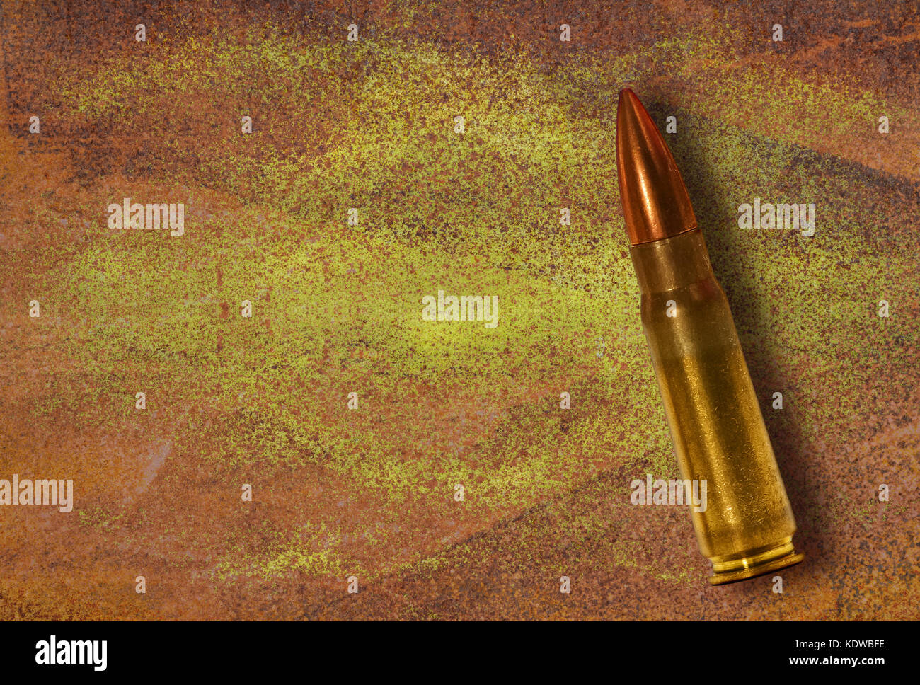 Closeup of a bullet on grunge yellow background Stock Photo - Alamy
