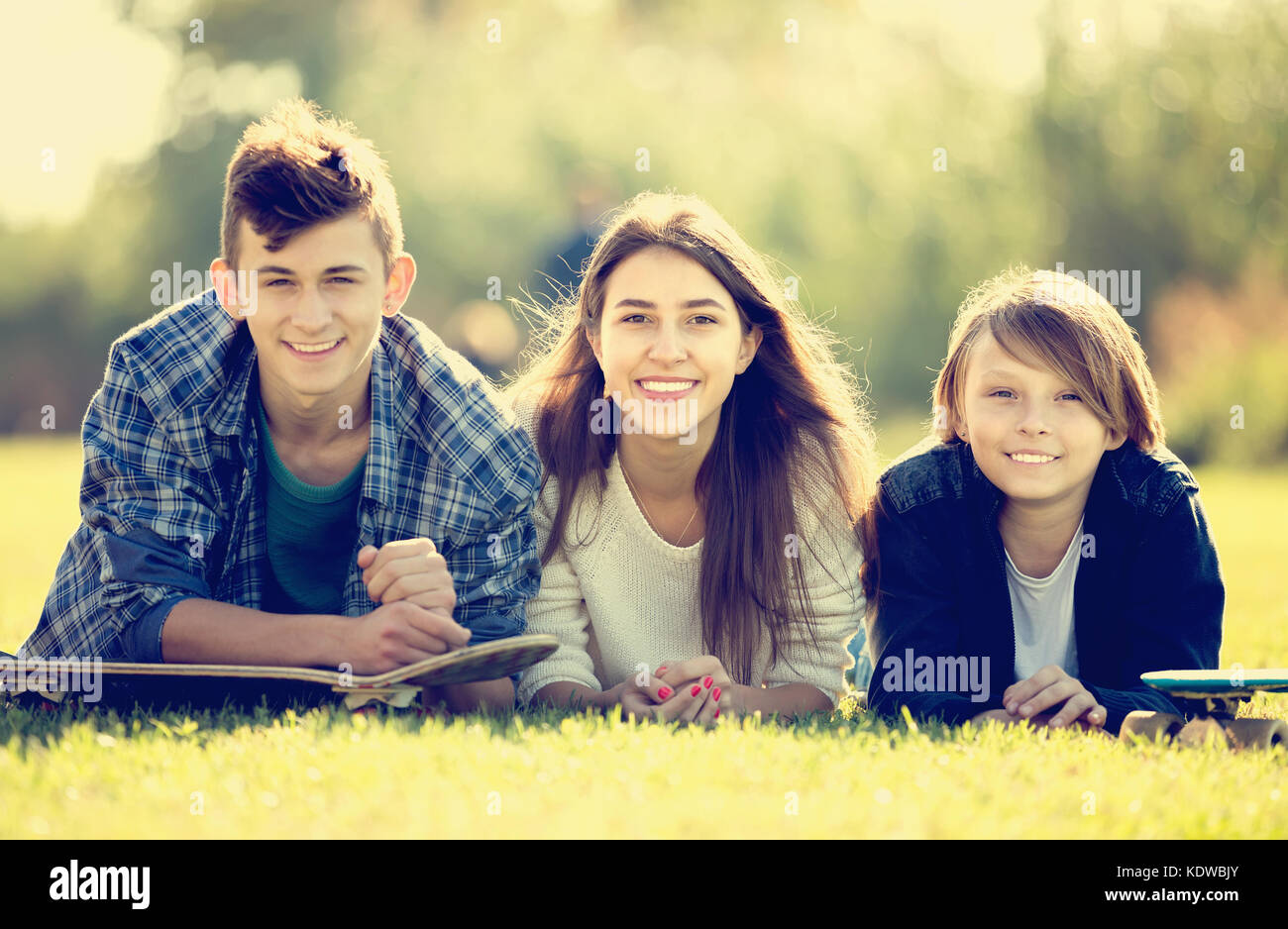 Portrait of smiling teenagers on countryside field in autumn day. Focus ...