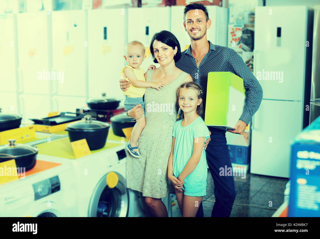 Happy family with two kids holding box with new electronics in home ...
