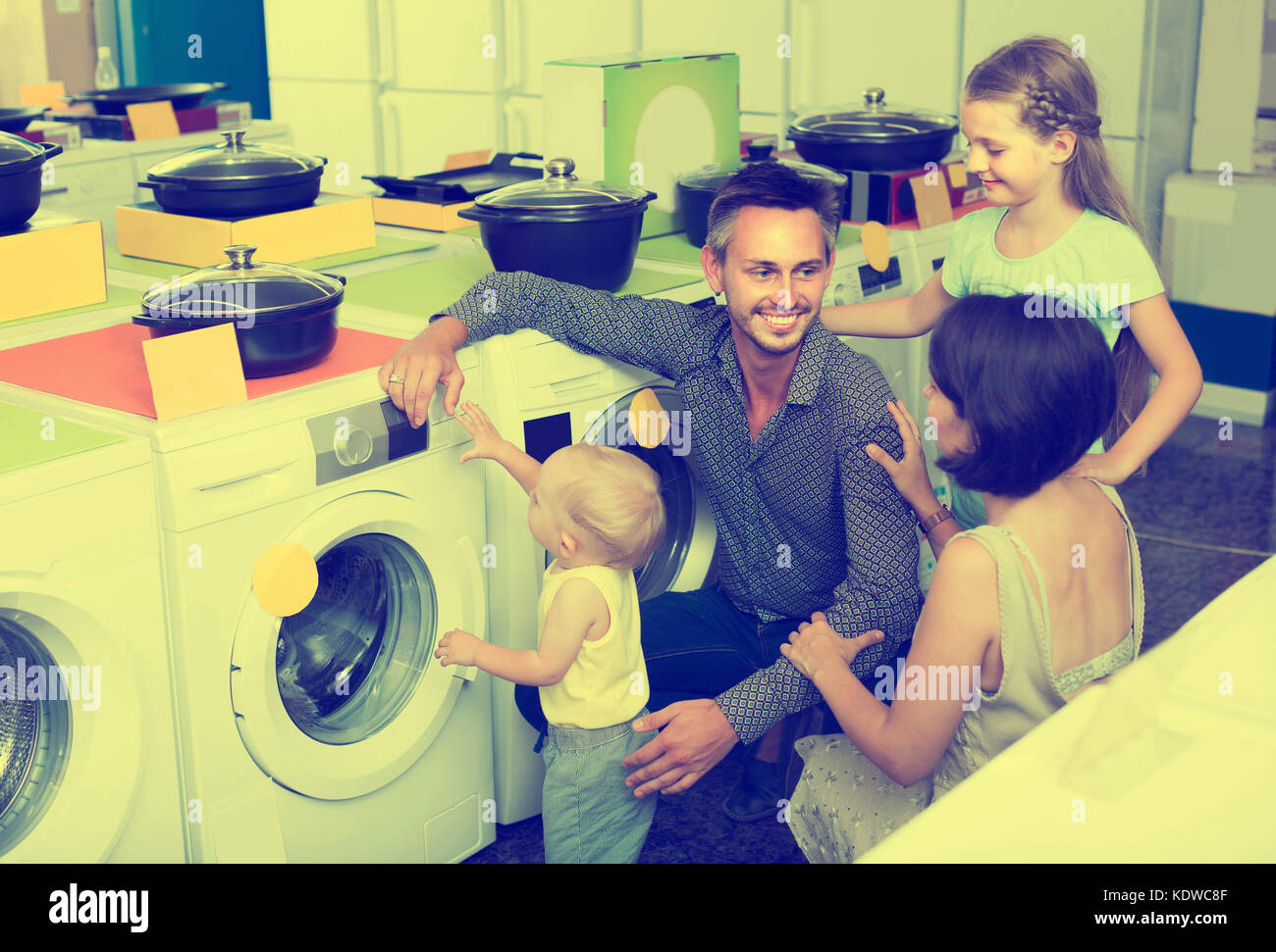 happy russian parents with two kids choosing washing machine in home ...