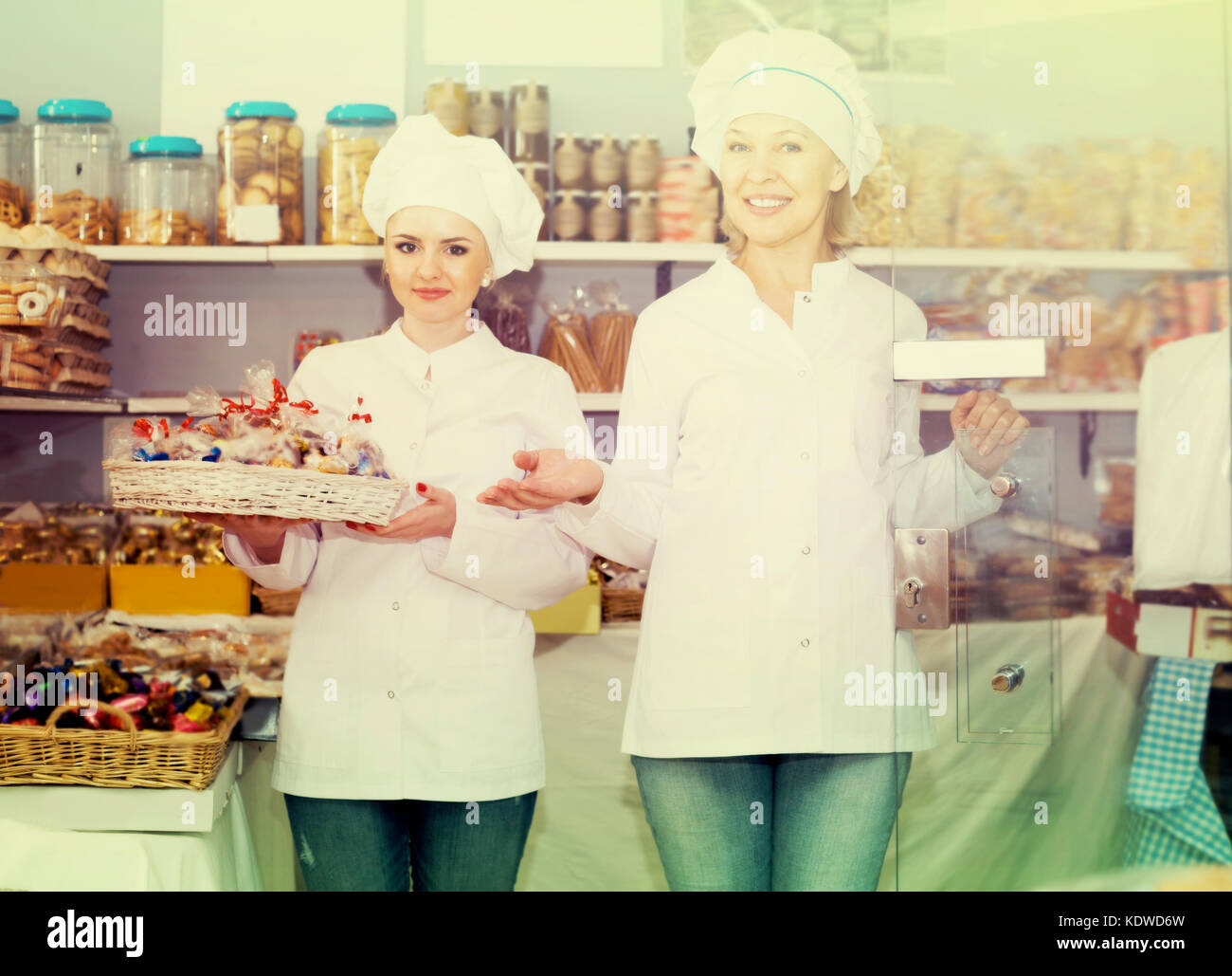 Friendly women staff offering sweets in local confectionery Stock Photo ...