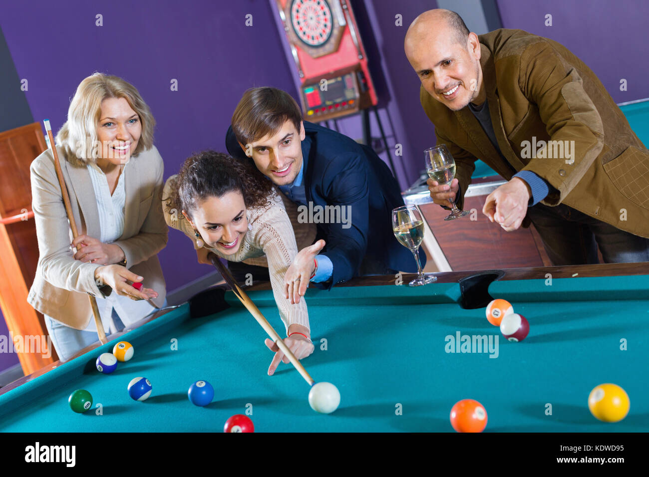 Relaxed cheerful people playing billiard and darts as hanging out Stock ...