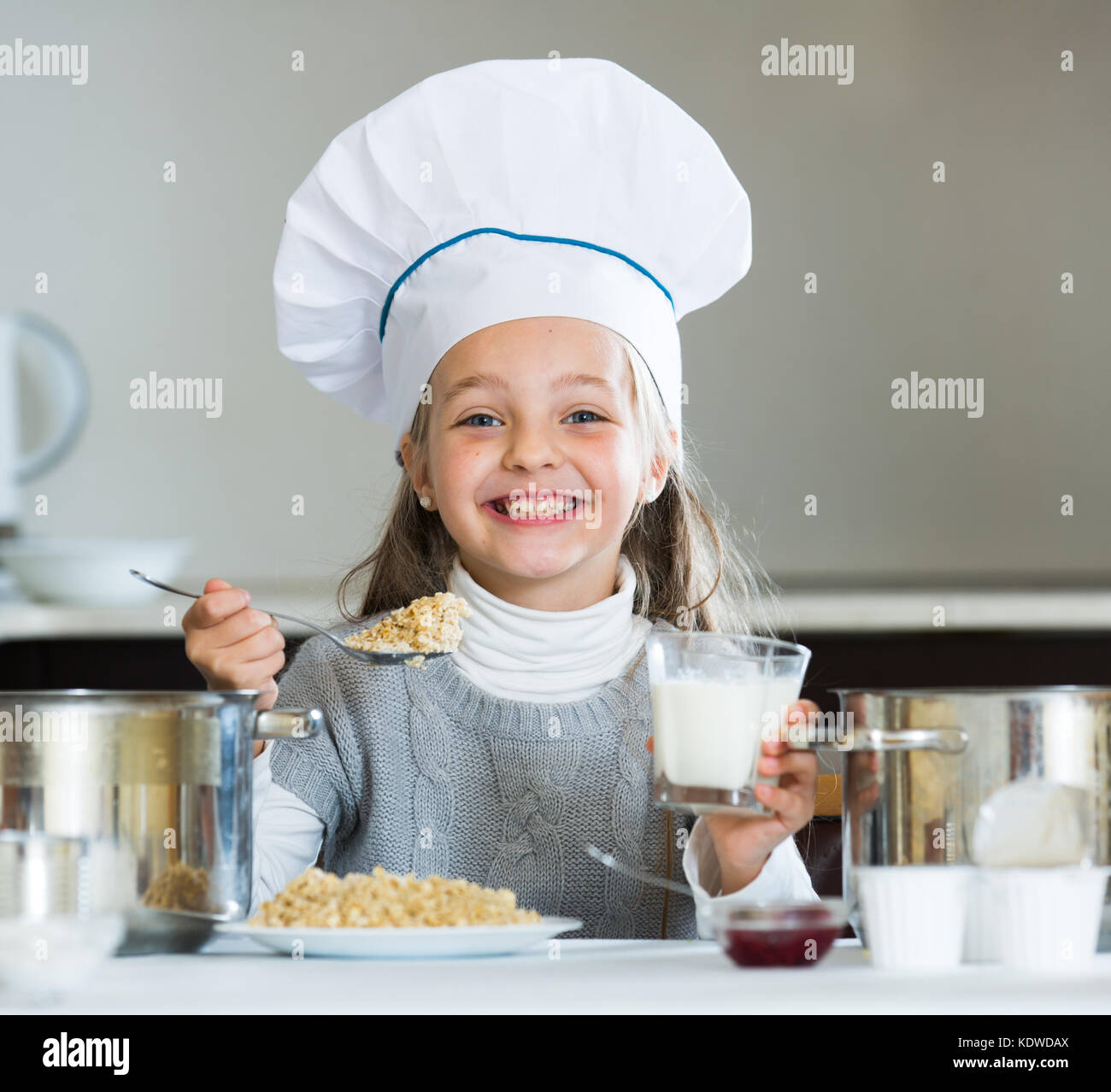 Little girl in cook hat with milk and oatmil kasha Stock Photo - Alamy
