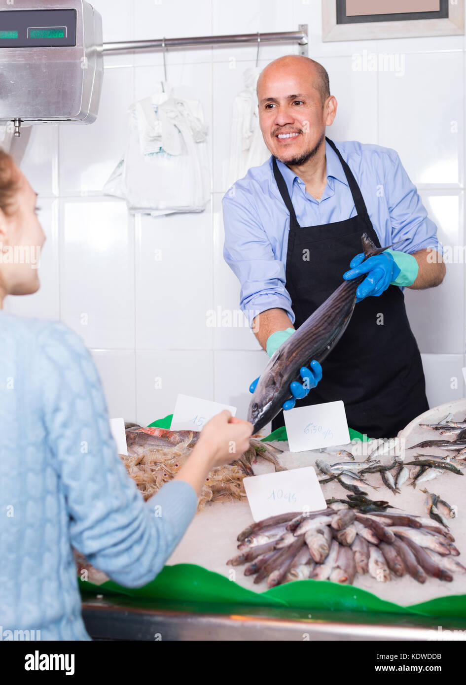 Young female customer choosing cooled fish in local fishery Stock Photo ...