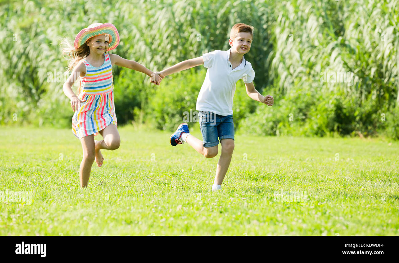 Two happy joyful children in elementary school age running together in ...