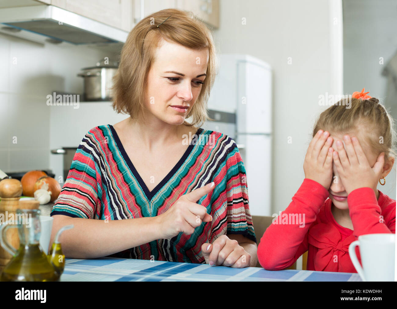 Young spanish woman lecturing small female child in the kitchen Stock ...