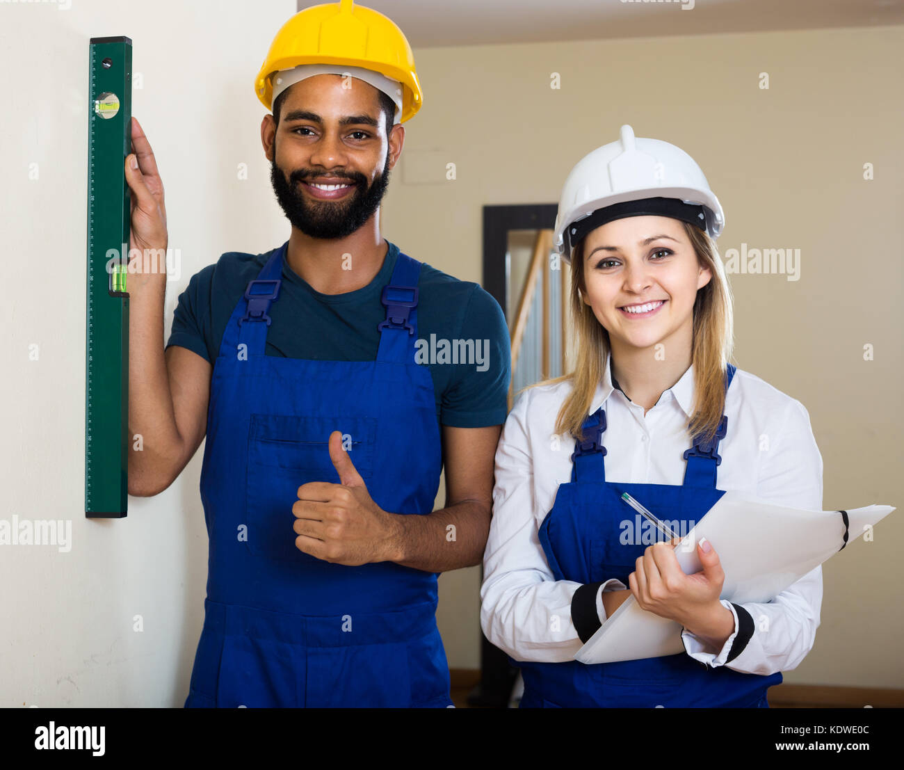 Constructor and happy european professional builder with spirit level ...