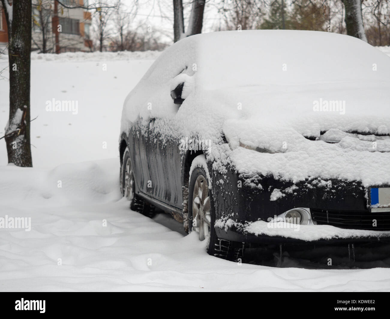 Snowfall in the city - Car covered by snow Stock Photo - Alamy
