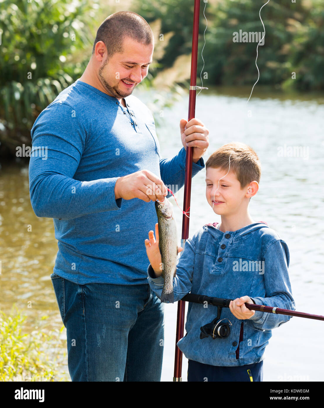Friendly father and son fishing with rods in summer day Stock Photo - Alamy