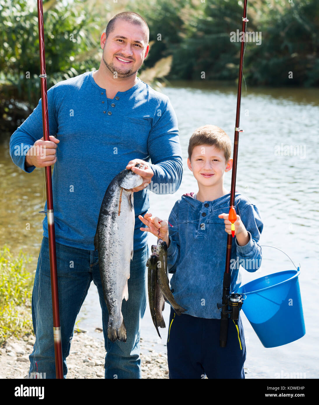 Laughing father and son fishing with rods in summer day Stock Photo - Alamy