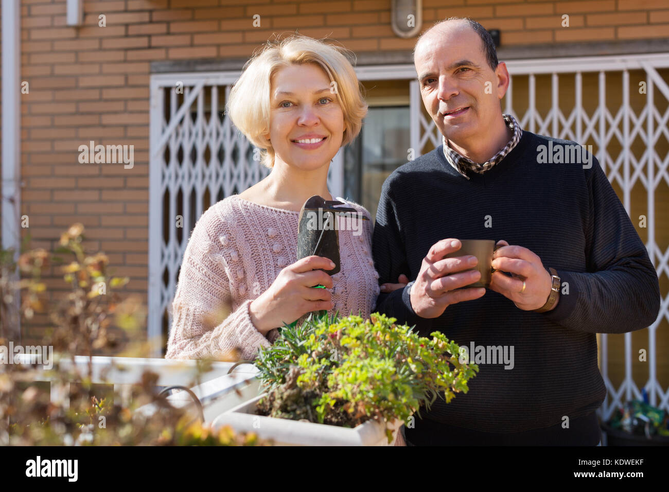 Elderly positive female talking with male neighbor at balcon Stock ...