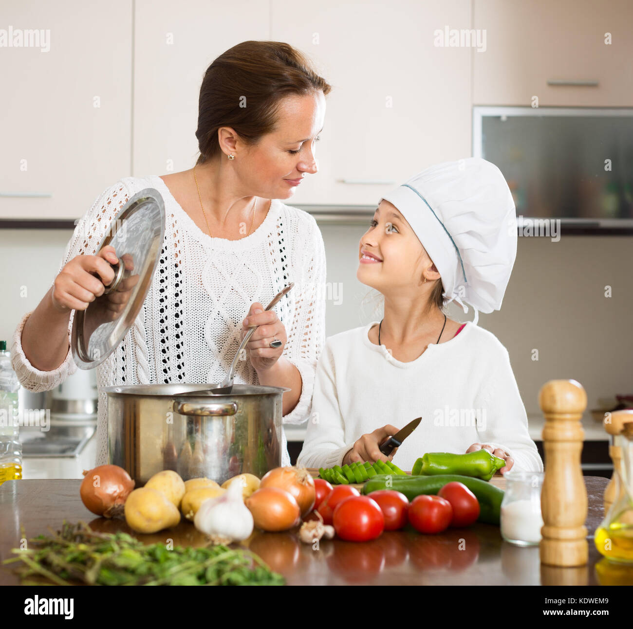 Portrait of happy girl and mom with vegetables and casserole at ...