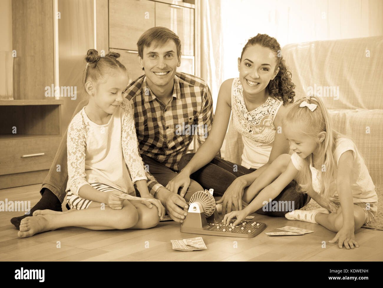Llittle girls with young smiling parents trying chances at lotto game ...