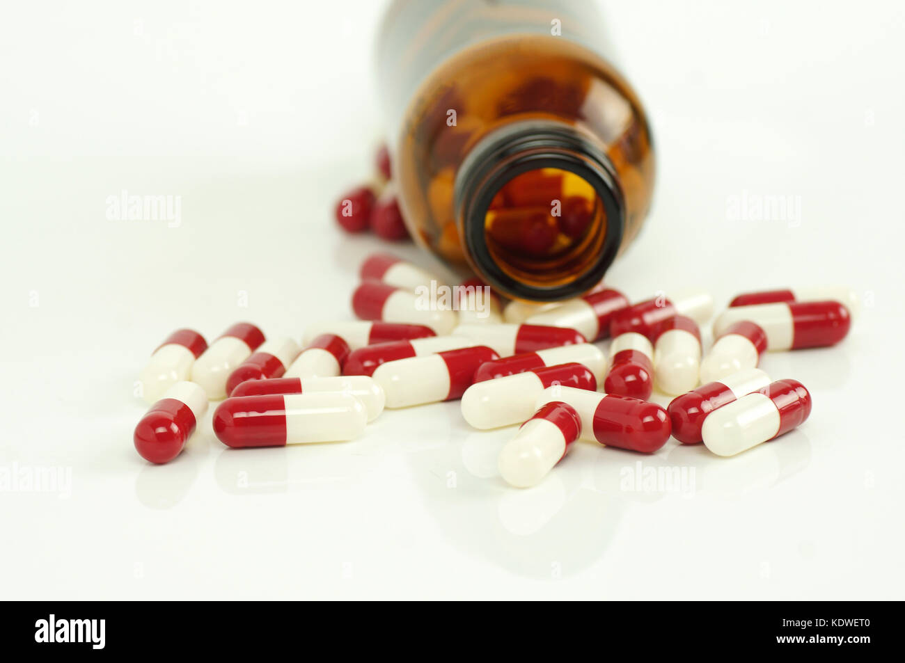 capsule and glass bottle on white background Stock Photo - Alamy