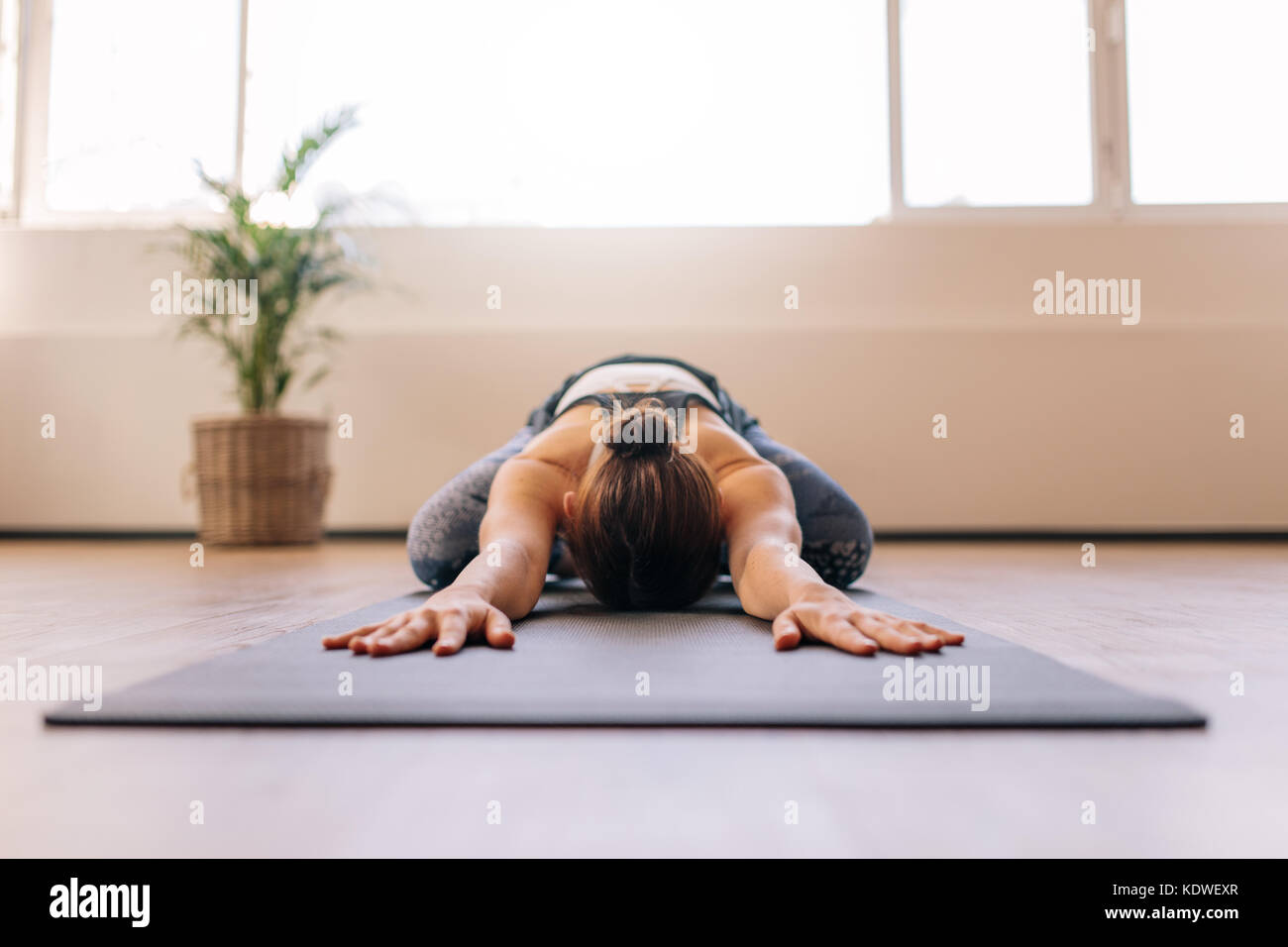 Fit woman performing child yoga pose at gym class. Fitness woman ...