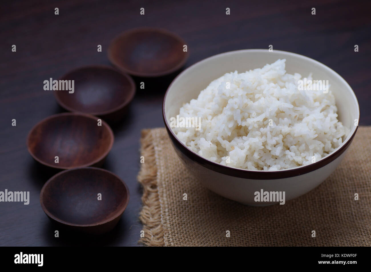 Thai rice in bowl with wooden empty and small bowl on table in dark ...