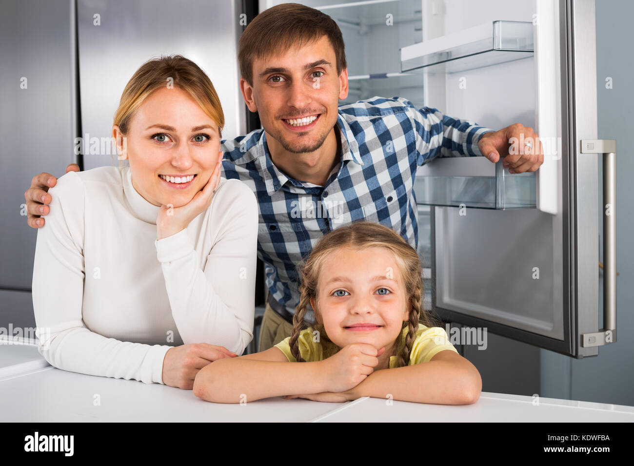 cheerful customers selecting new refrigerator in appliance shop Stock ...