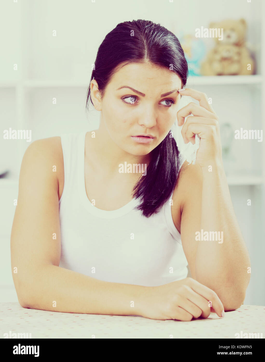 Young brunette woman sitting at table and crying Stock Photo - Alamy