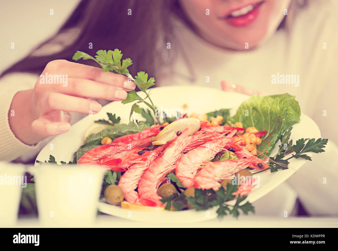 Smiling young brunette girl decorating fried fish on plate Stock Photo ...
