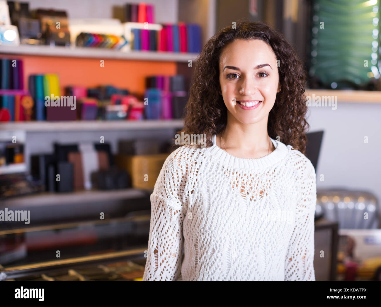 Portrait of friendly smiling shopgirl in haberdashery shop Stock Photo ...