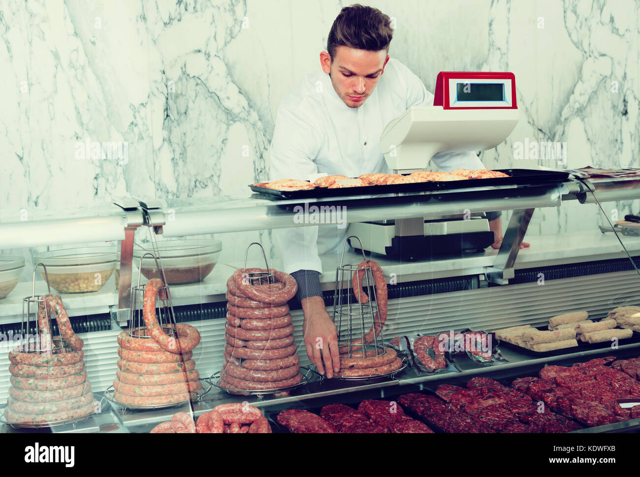 Positive adult ordinary man seller working at meat market Stock Photo ...