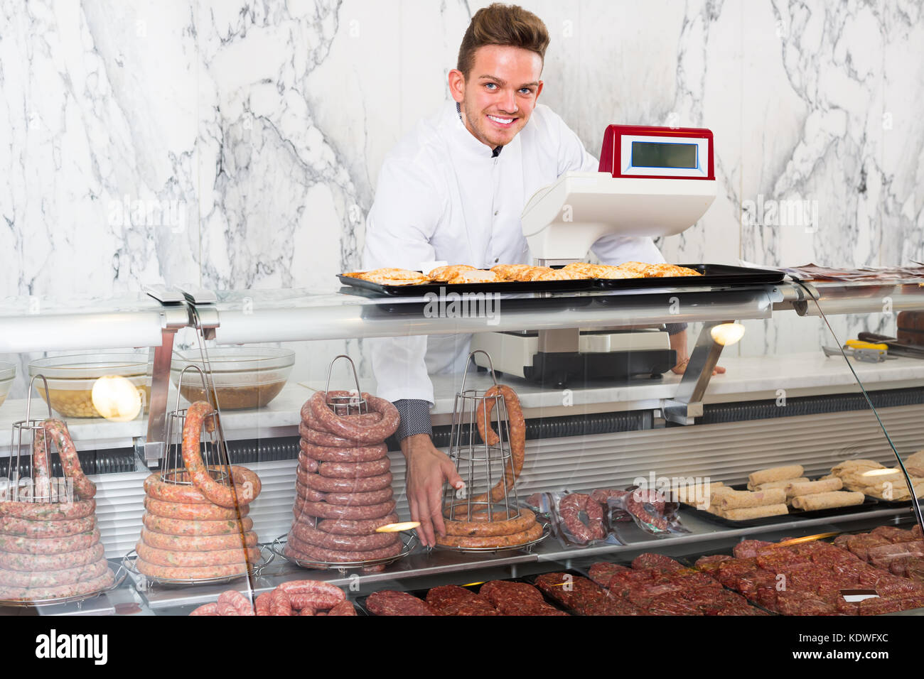 smiling man cook cutting raw meat pieces in butcher market Stock Photo ...
