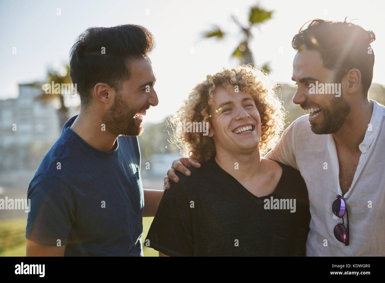 Three male friends standing together hi-res stock photography and ...