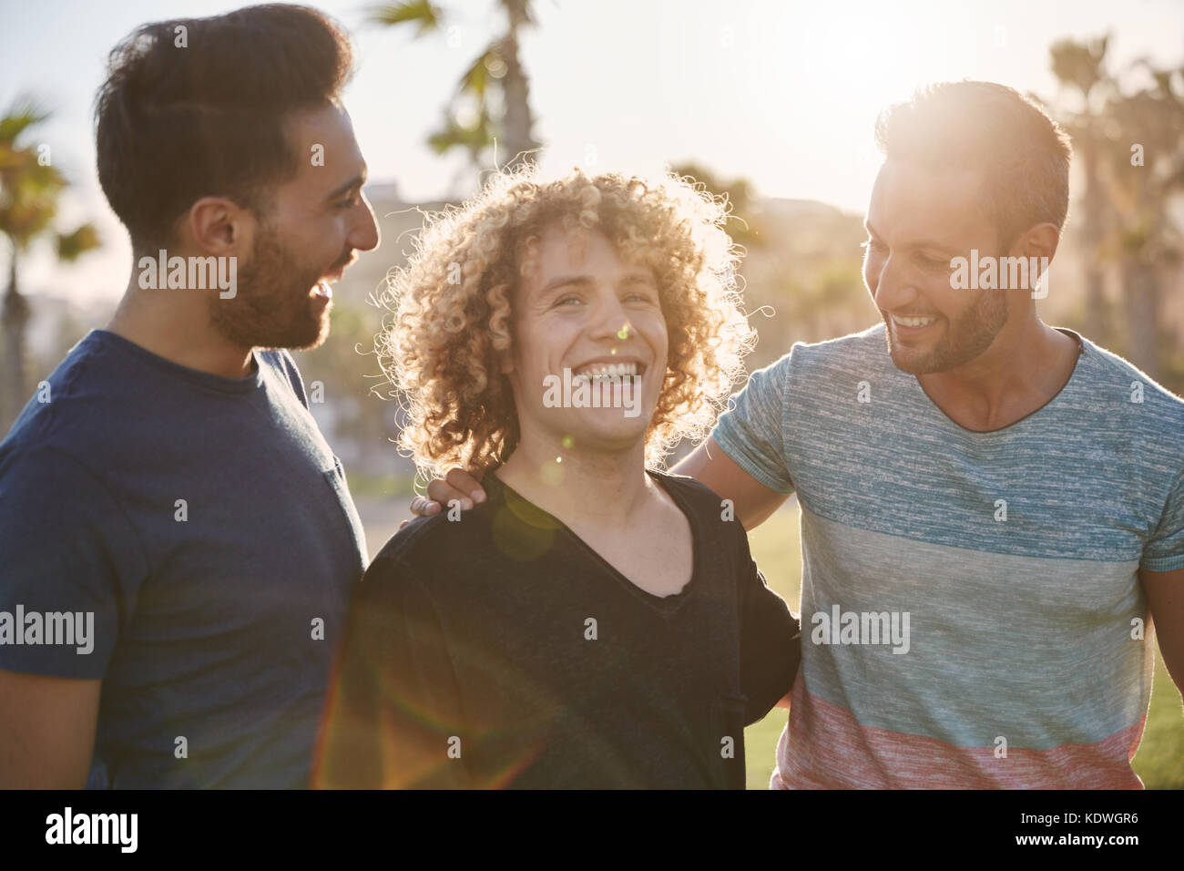 Portrait of three happy male friends laughing together outside Stock ...