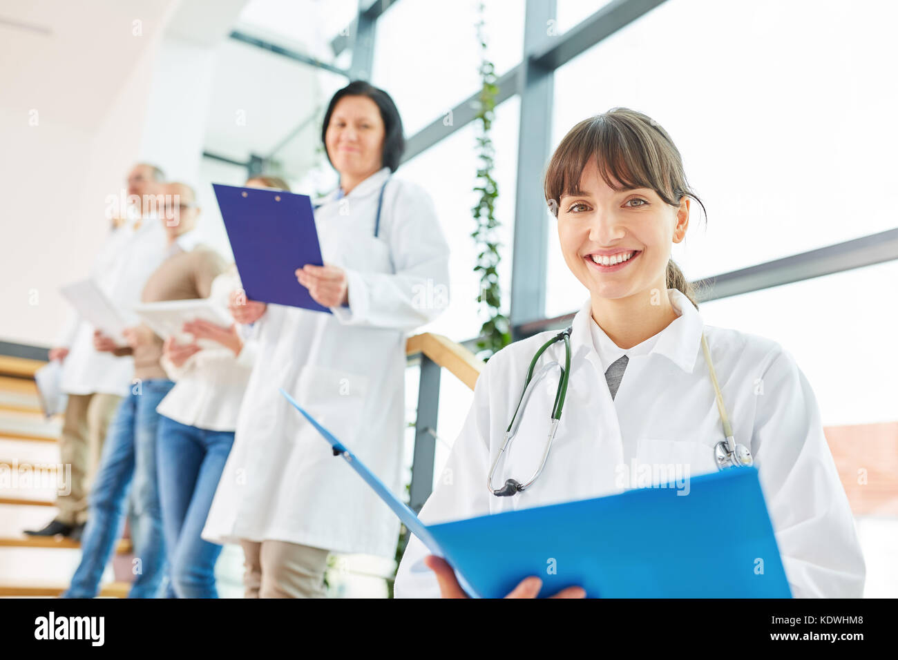 Young woman as doctor or nurse in medicine apprenticeship with team of doctors Stock Photo - Alamy