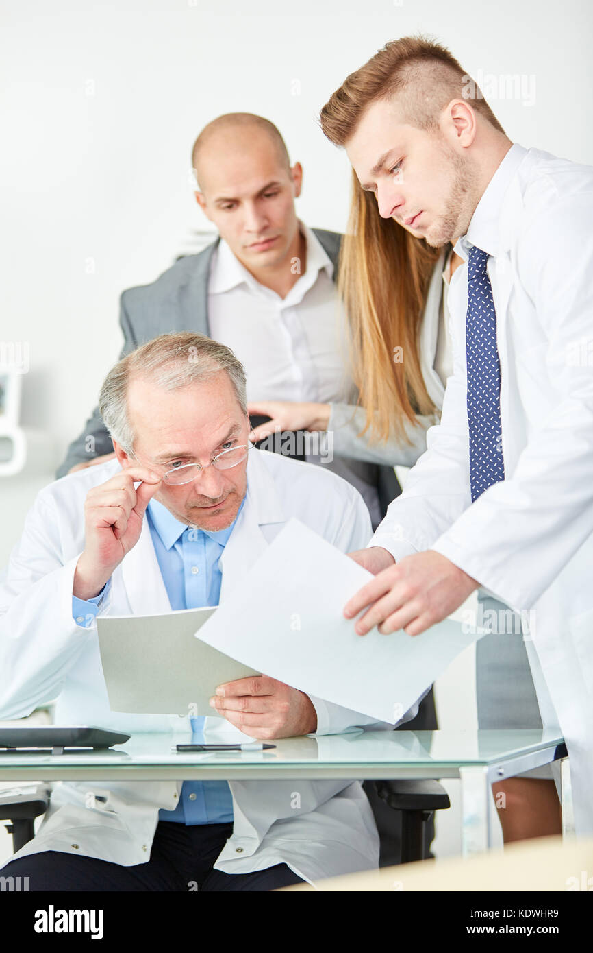 Senior physician as clinic chief executive with team of doctors Stock ...