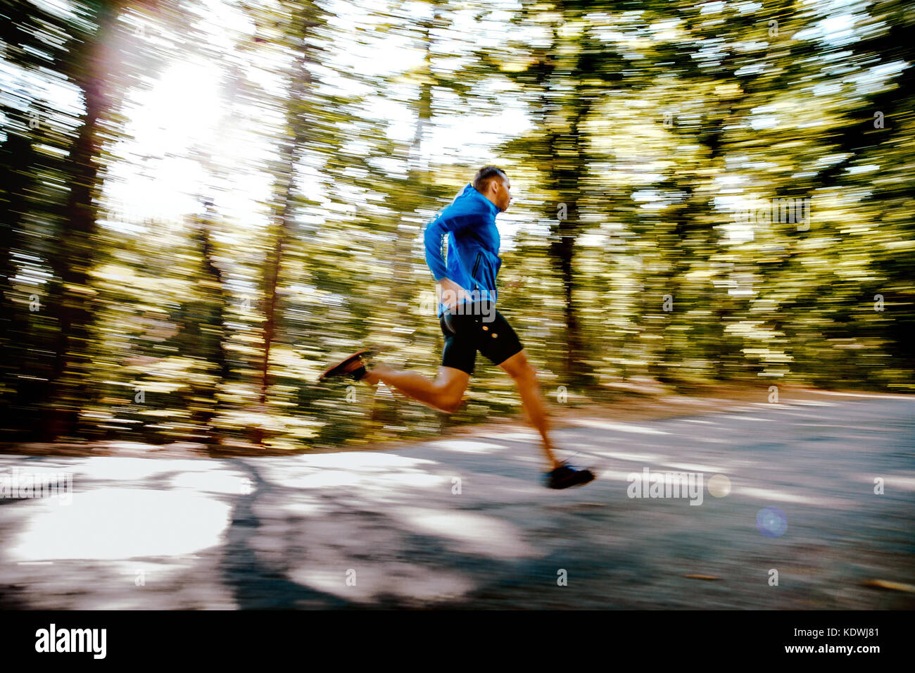 fast running man runner in forest road blurred motion Stock Photo - Alamy