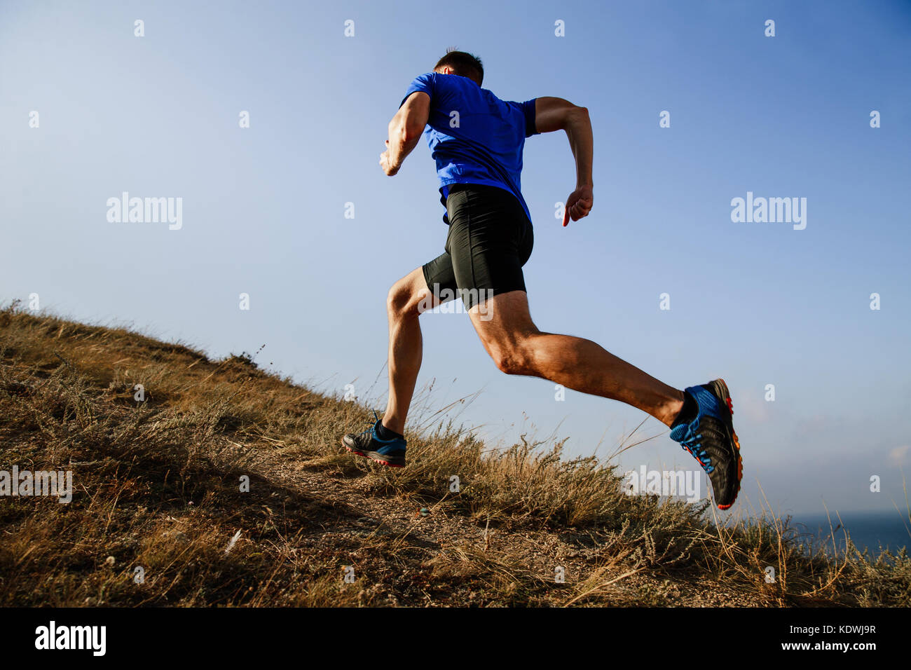 dynamic running uphill on trail male athlete runner side view Stock ...