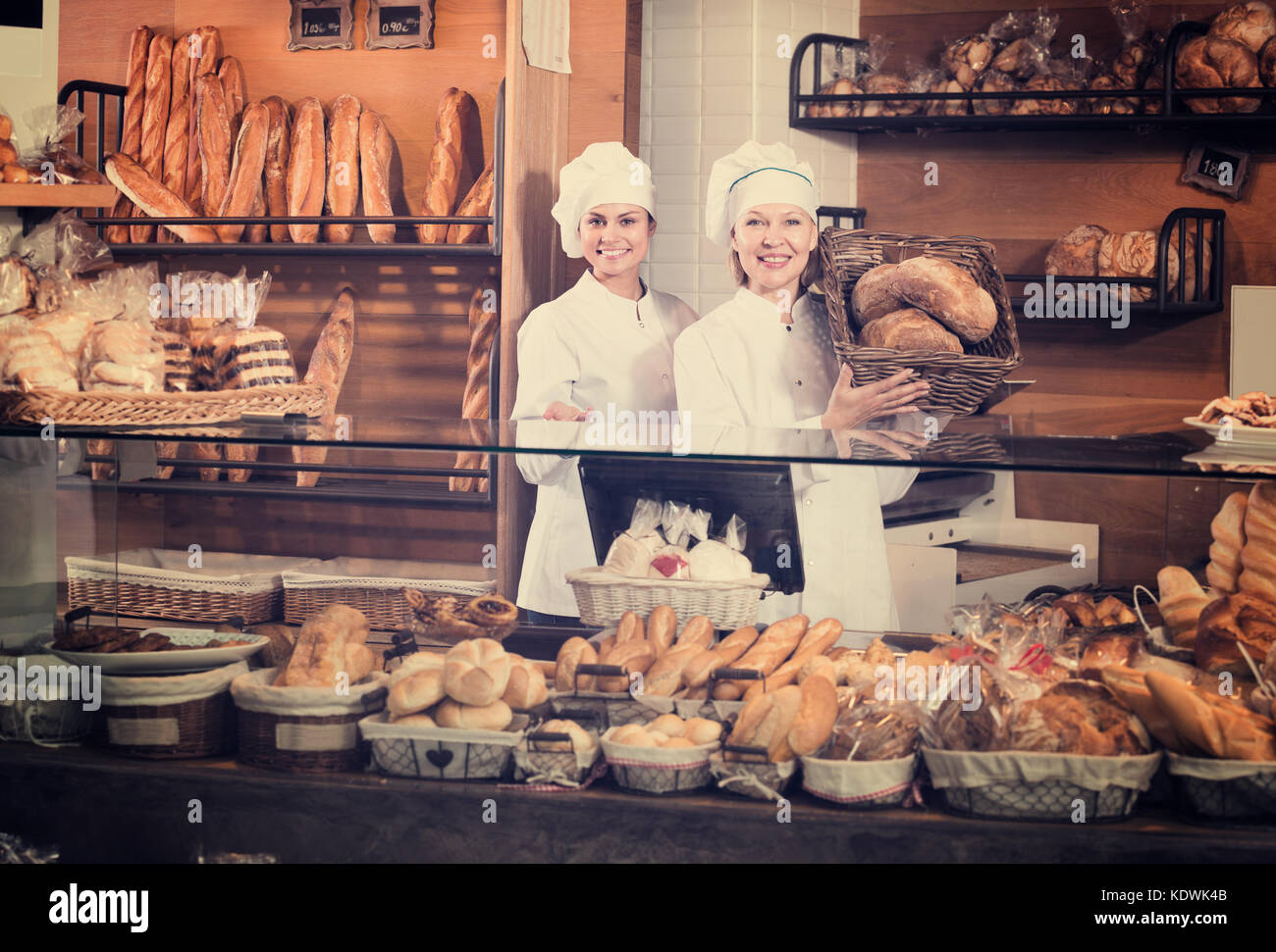 Bakery staff offering bread and different pastry for sale in interior ...