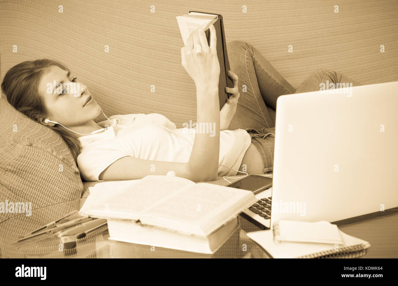 Smiling young girl using book at home Stock Photo - Alamy