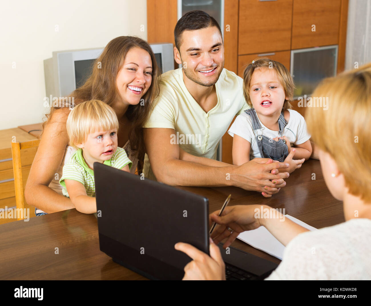 Insurance agent consulting happy smiling family with kids at home ...
