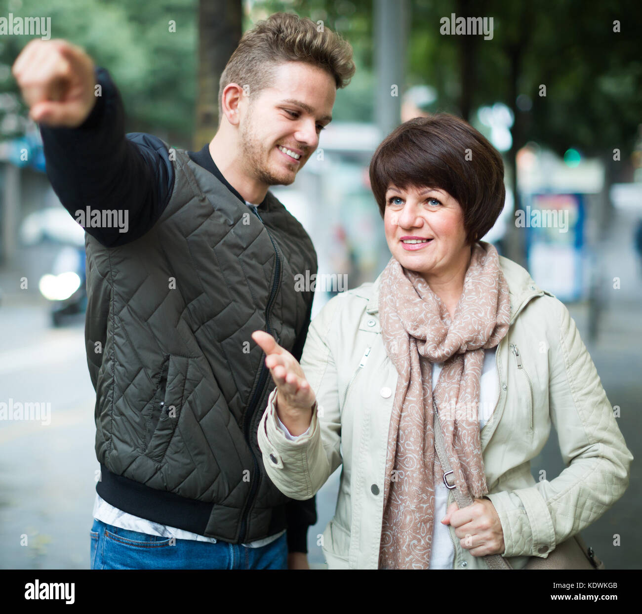 Glad man points the direction to woman outdoor Stock Photo - Alamy