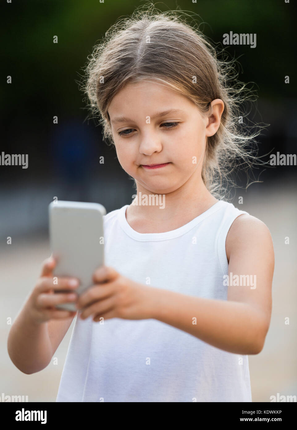 Portrait of serious pretty girl in elementary school age looking at ...