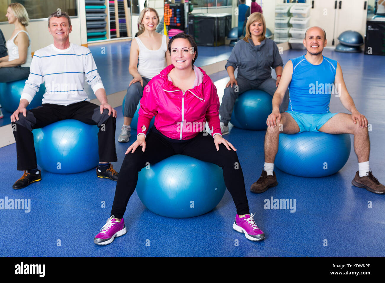 Group of active adults doing aerobics with balls in a sport club Stock ...