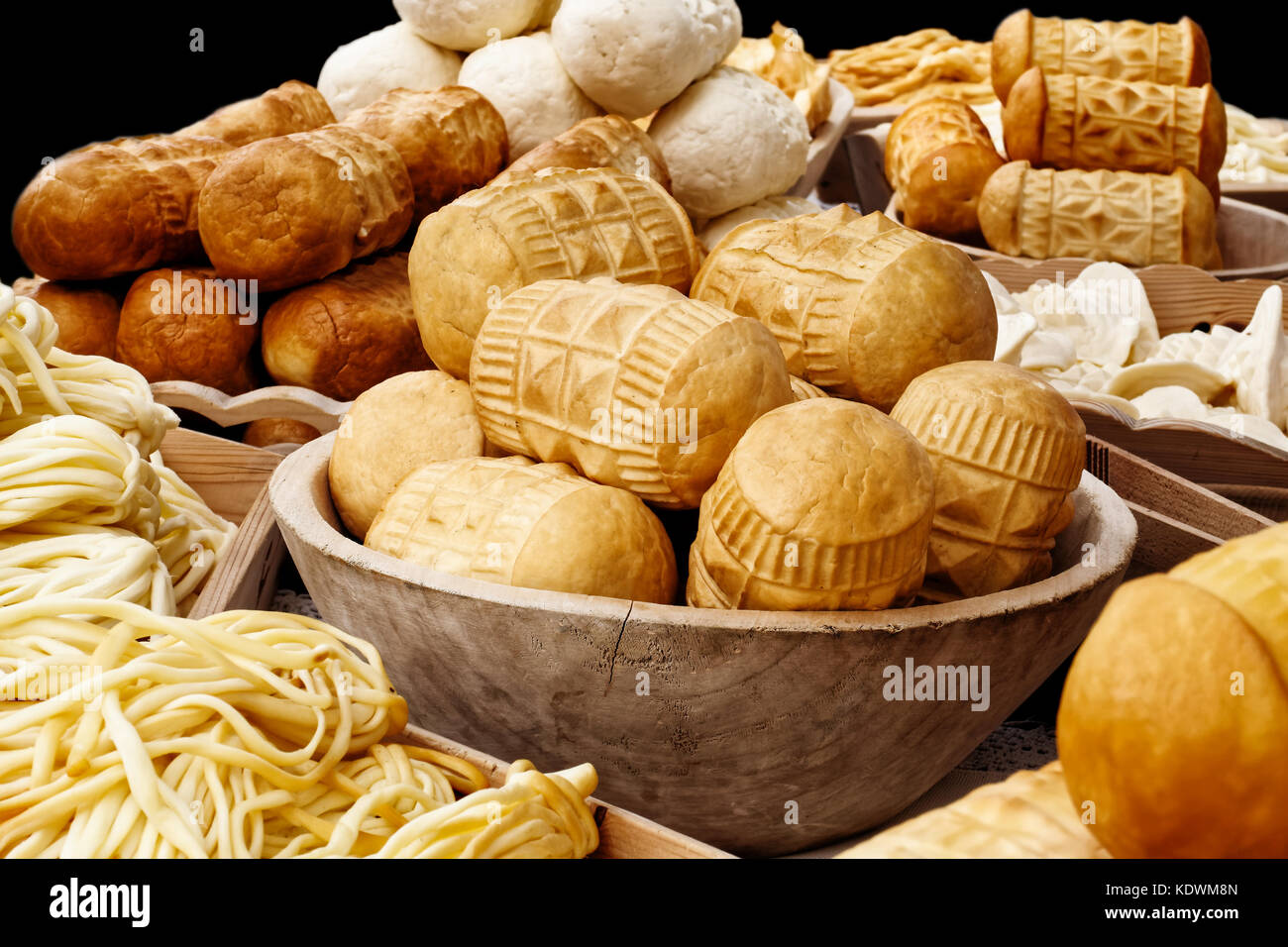 Many kinds of oscypek smoked cheese next to korbacik cheese on black ...