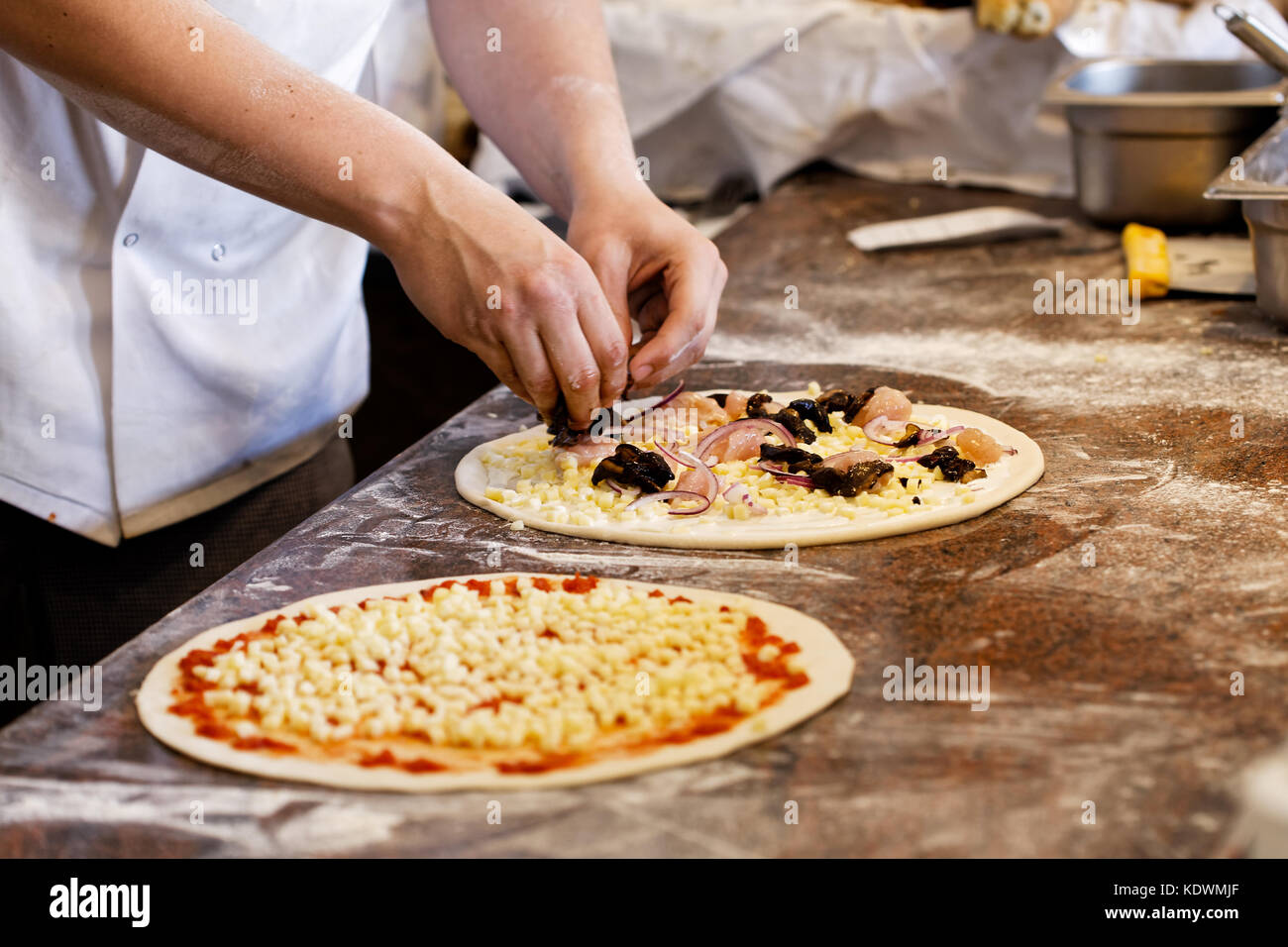 Cook putting ingredients on pizza hi-res stock photography and images ...