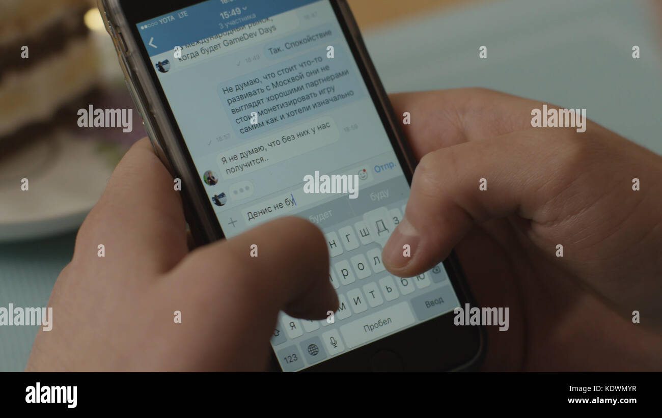 Hands of a man are writing a sms on a smartphone. Man write a message ...