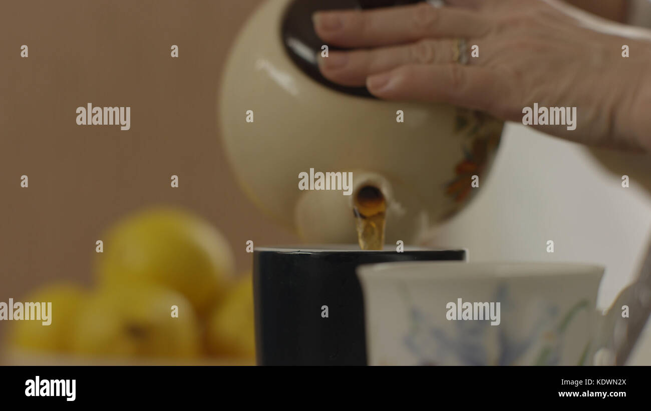 Woman's hand pour tea from teapot into the glass Stock Photo - Alamy